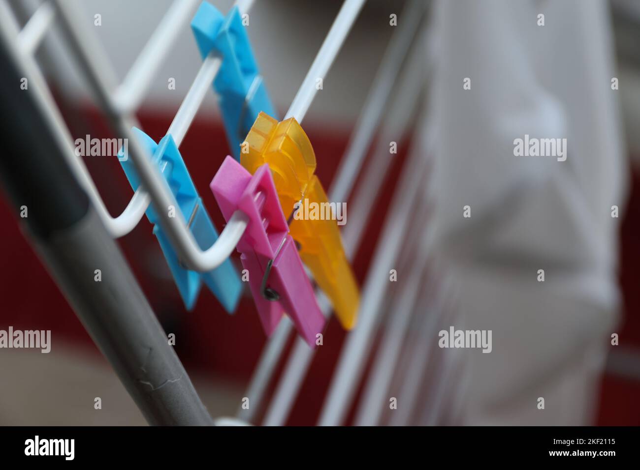 A portrait of two colorful washingpins hanging on a laundry rack ...