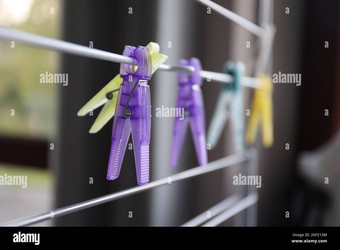 a close up portrait of a purple washingpin hanging on a washing rack ...