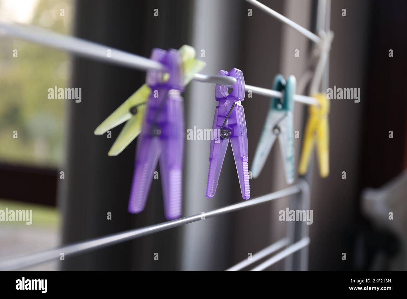 a close up portrait of a purple washingpin hanging on a washing rack ...
