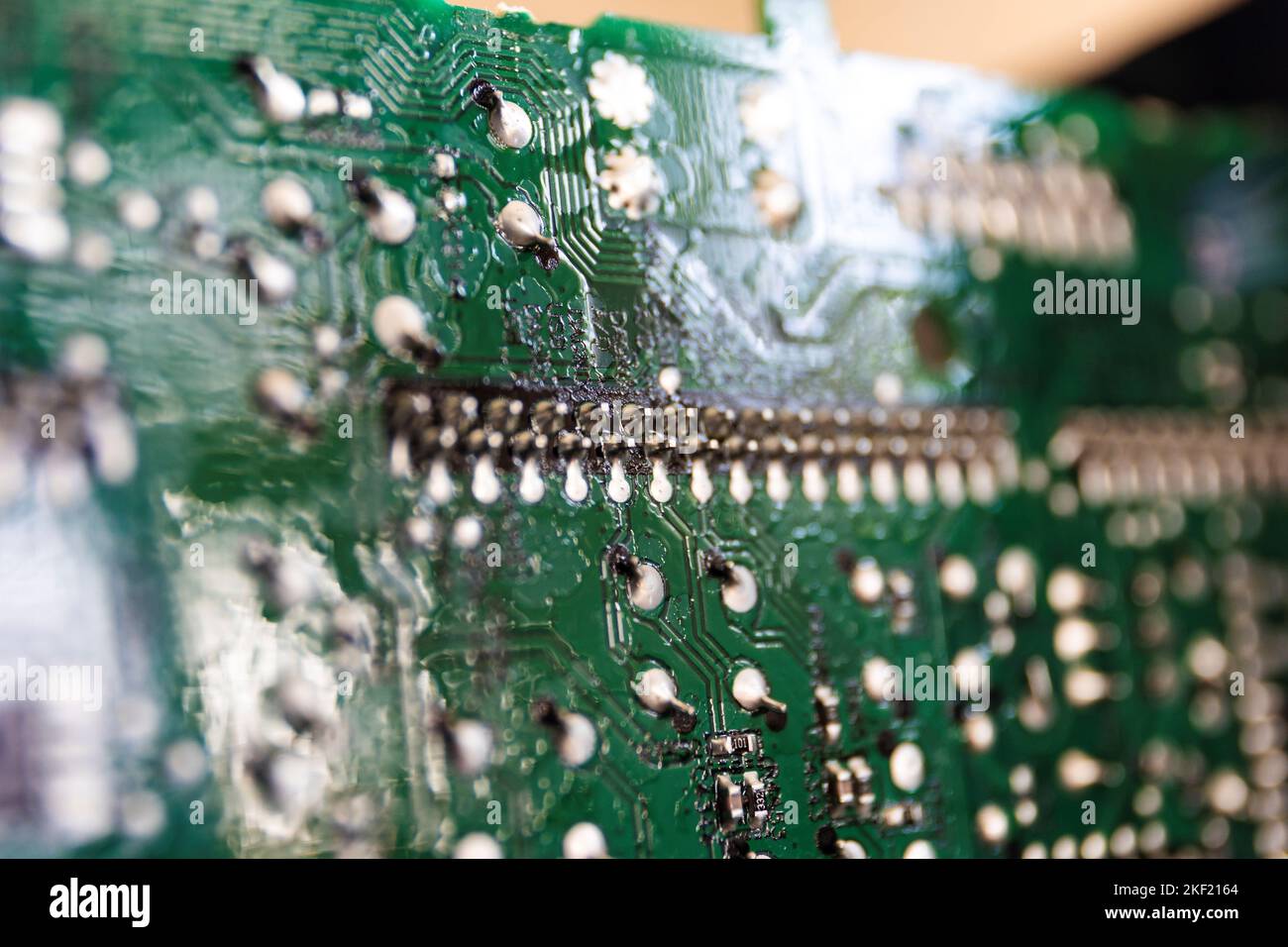 a close up portrait of a green electric circuit with a lot of soldering ...