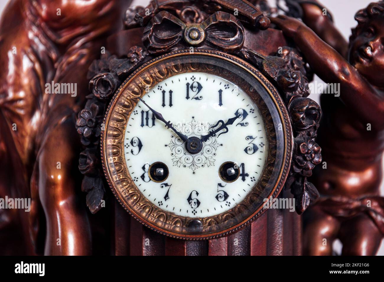 A portrait of an old vintage clock with a stylish clock face and hands ...