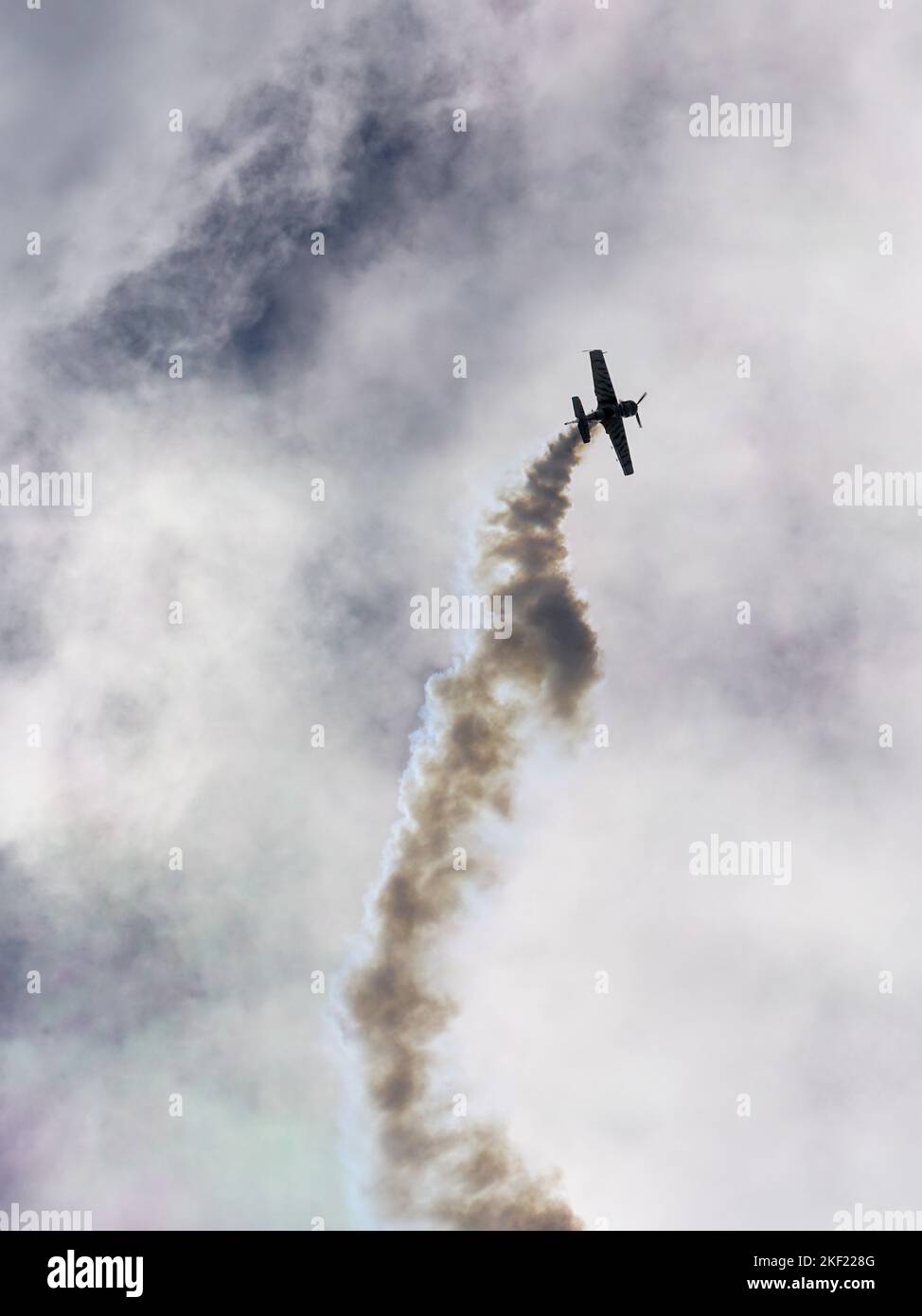 A light sport airplane performing aerobatic maneuver stunts in a cloudy ...