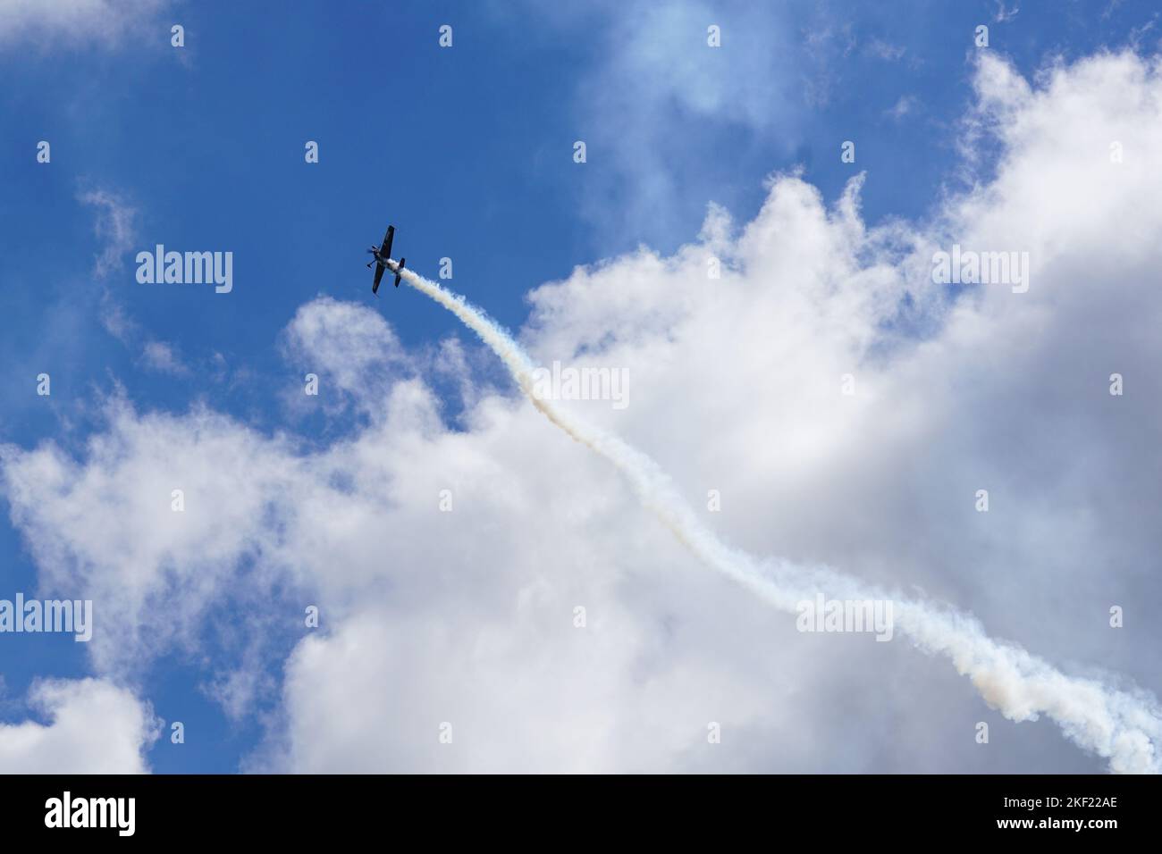 A light sport airplane performing aerobatic maneuver stunts in a cloudy ...