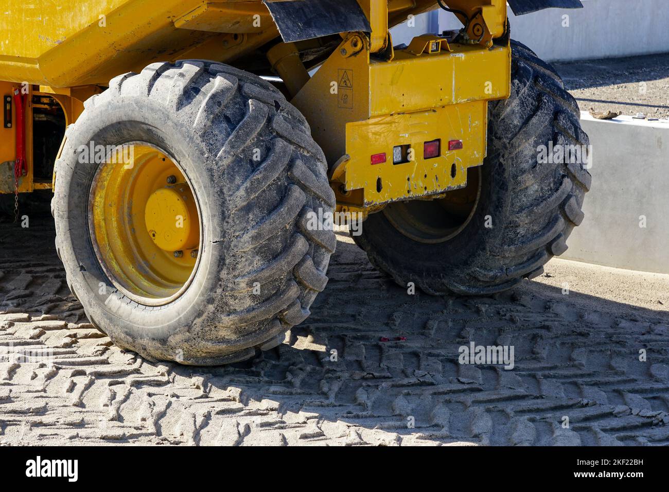 Large wheels with black rubber tires of a yellow construction machine ...