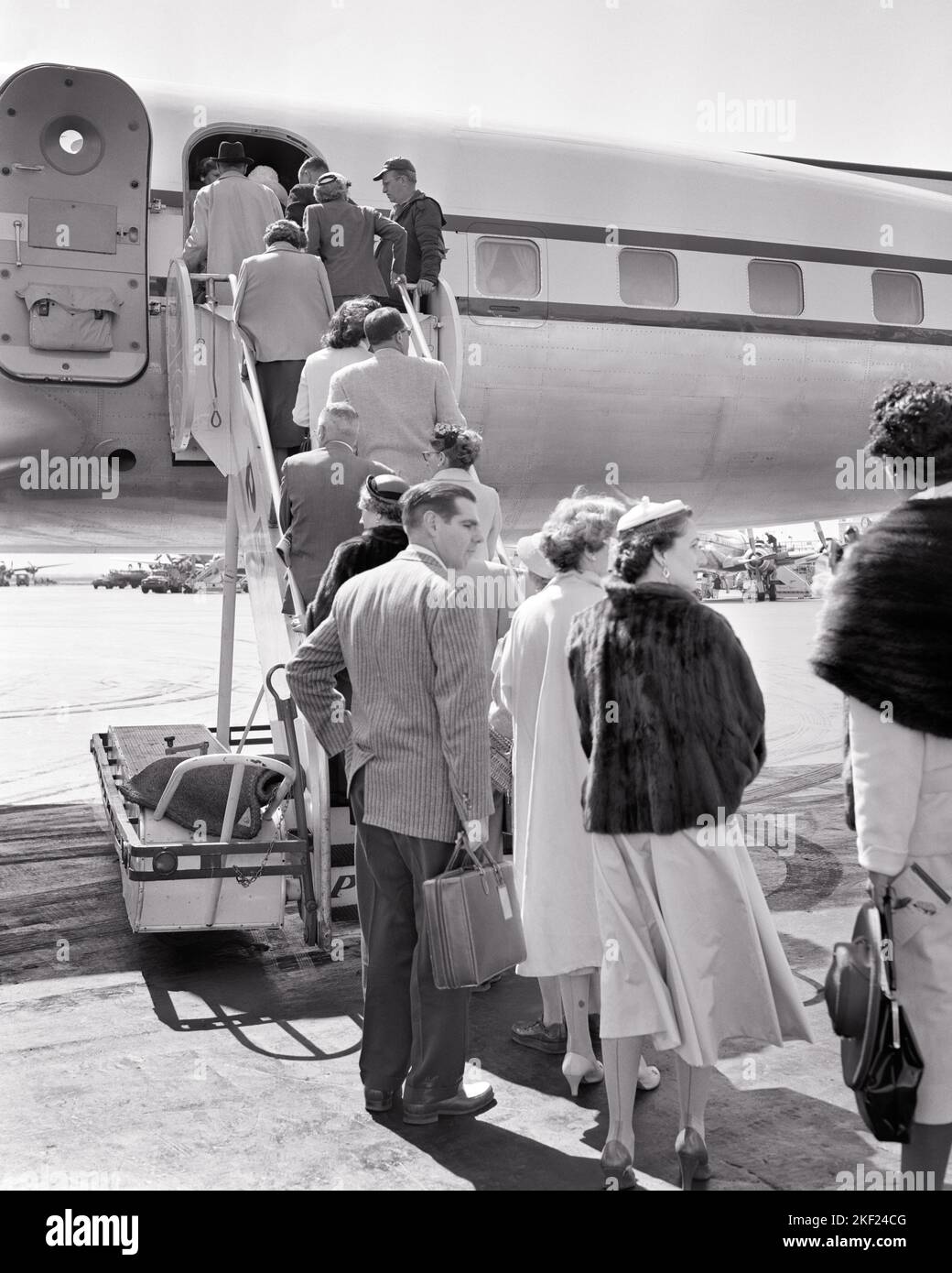 1940s 1950s AIRLINE PASSENGERS BOARDING AIRCRAFT IN LINE ON TARMAC ...