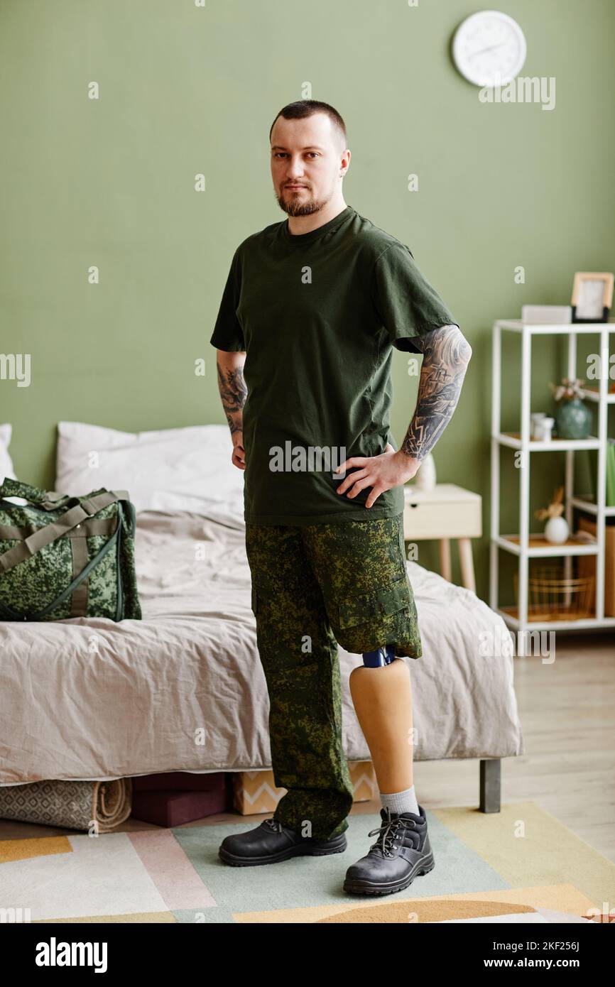 Full length portrait of military veteran with prosthetic leg wearing ...