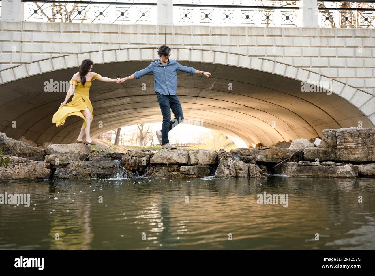 A couple by a bridge in Forest Park, flirting and exploring together ...