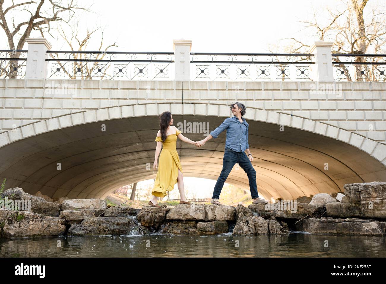 A couple by a bridge in Forest Park, flirting and exploring together ...