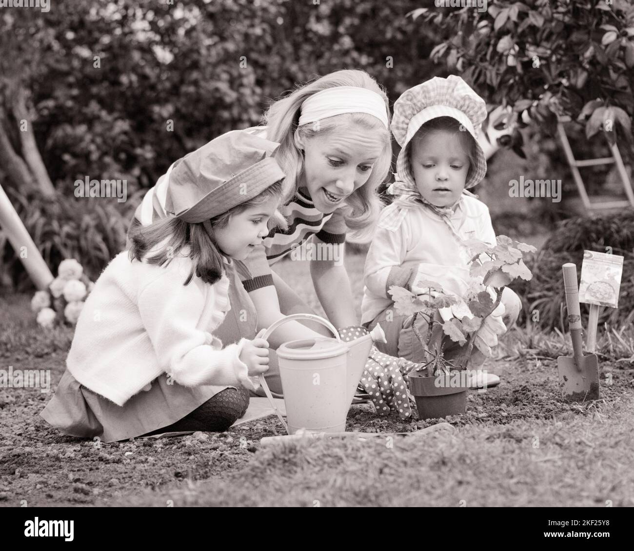 1960s 1970s WOMAN MOTHER AND TWO SMALL GIRLS DAUGHTERS SISTERS WORKING ...