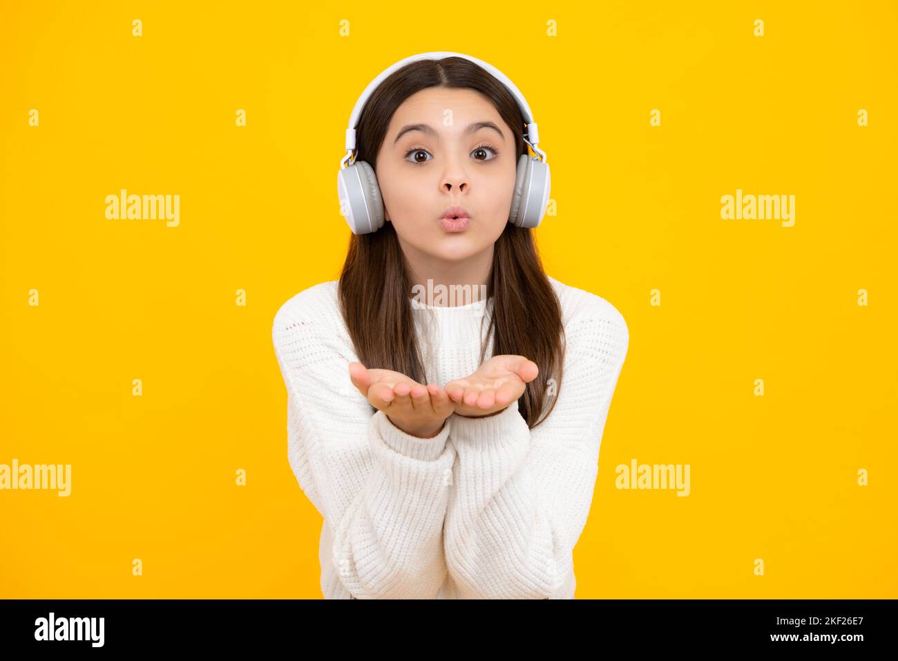 Funny face. Teen girl in headphones listen to music. Wireless headset ...