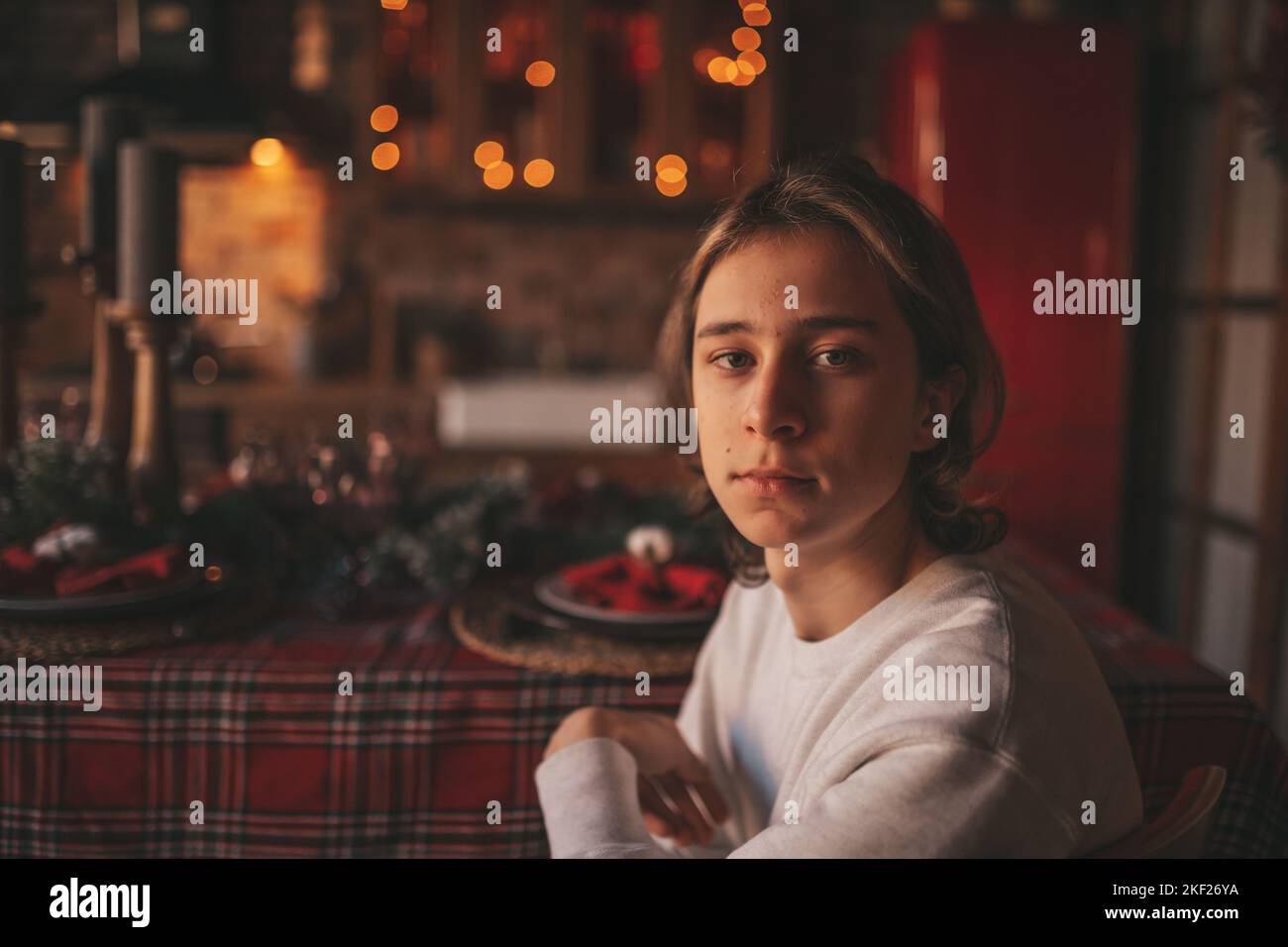 Young teen boy with long hair thoughtful look sad eyes negative mood ...