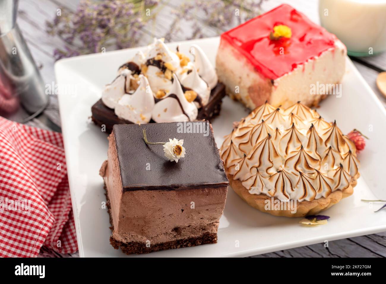 A white square plate with mini sweet cakes on a wooden table Stock ...