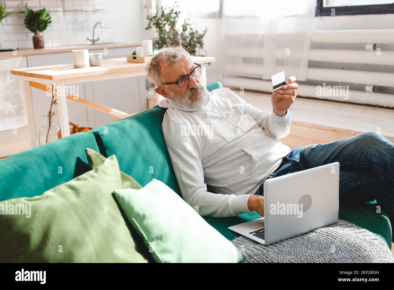 Senior elderly man making online payments using laptop. Old grandfather ...