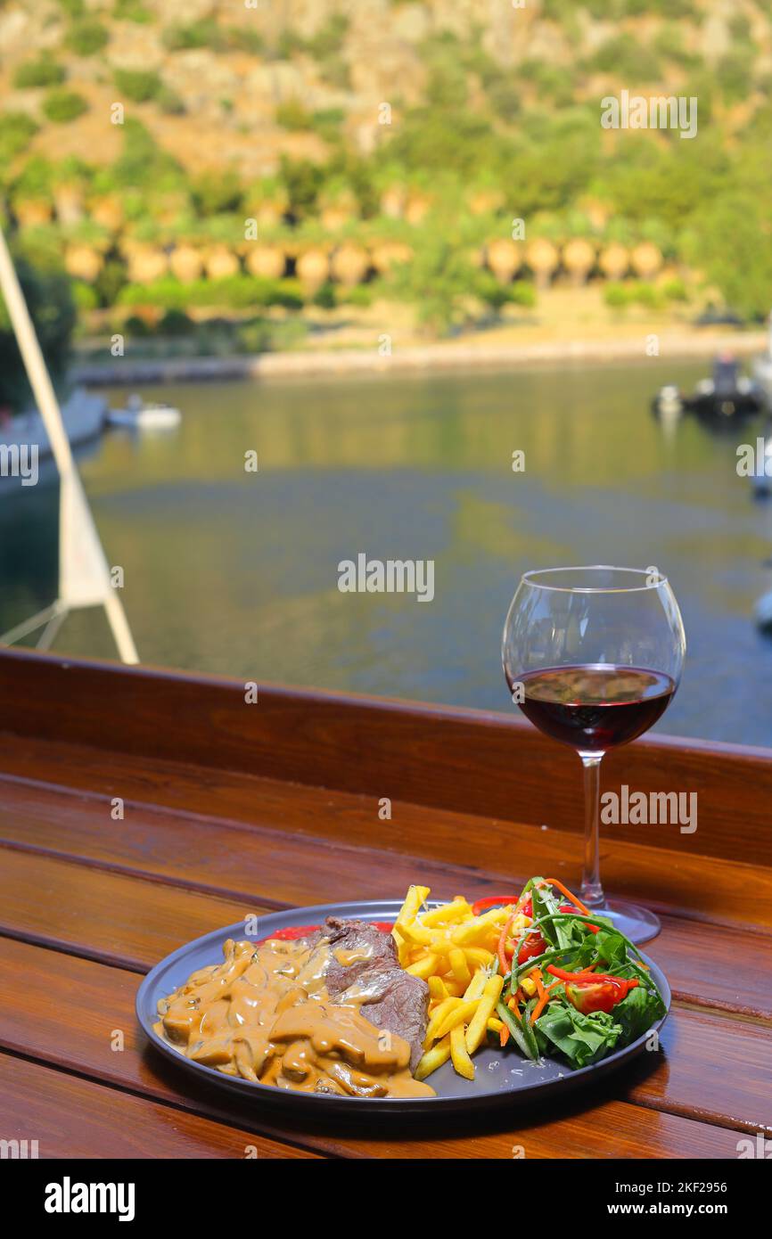beef chop steak with salad , fried potatoes and mustard sauce in dish ...