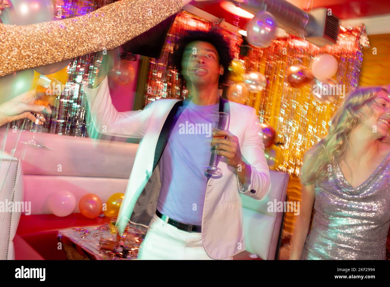 Happy diverse couple dancing and drinking champagne at nightclub Stock ...