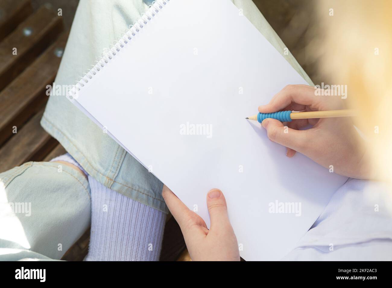 Anonymous girl making notes or drawing in the blank paper book,overview ...
