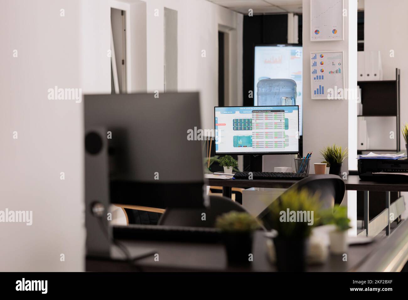 Workstations with desktop devices on wooden desks in contemporary ...