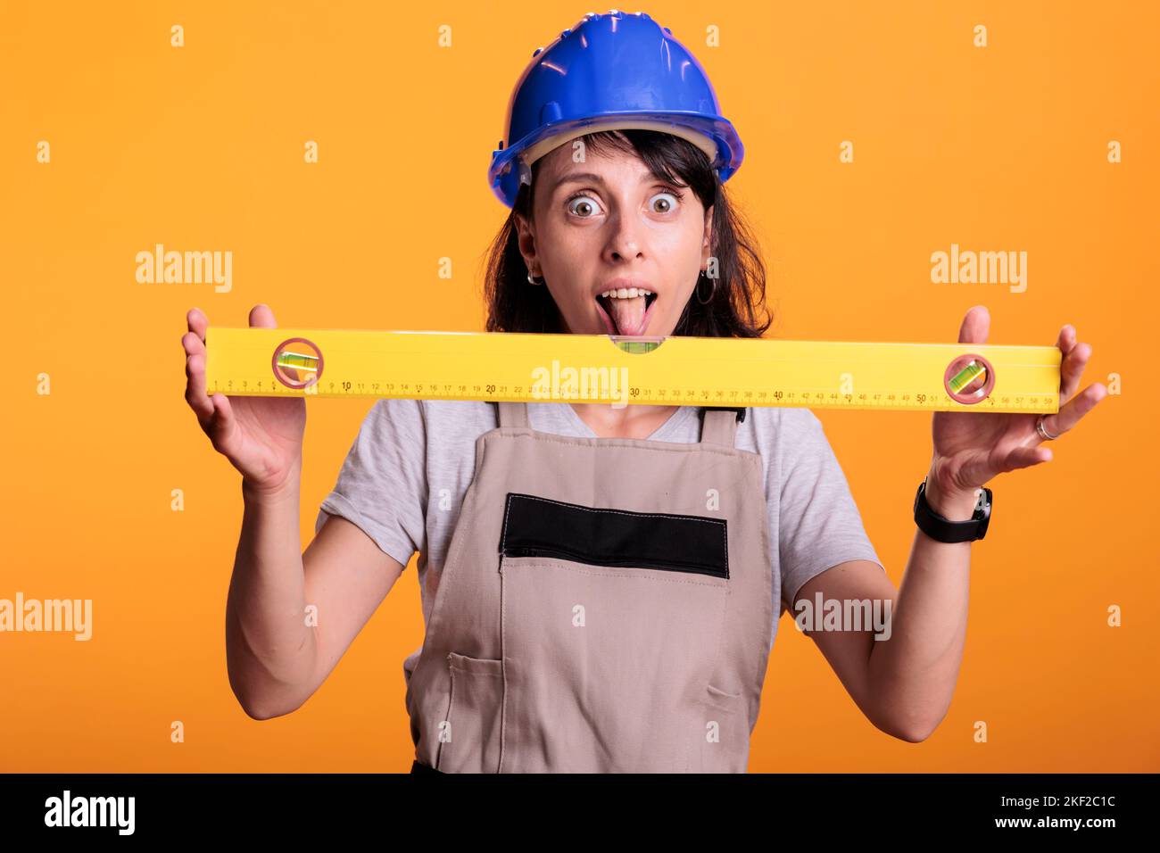 Cheerful construction worker using leveler to check flat walls, working ...