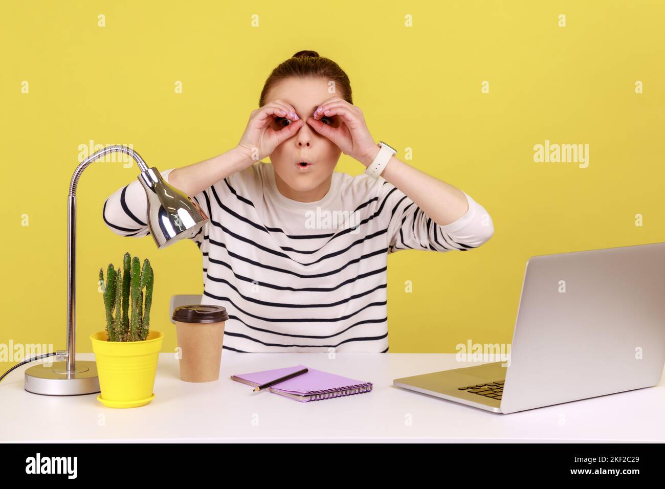 Astonished shocked woman office worker sitting at workplace holding ...