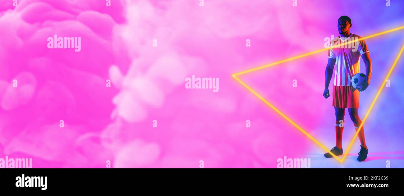 African american male with ball by illuminated triangle standing over ...