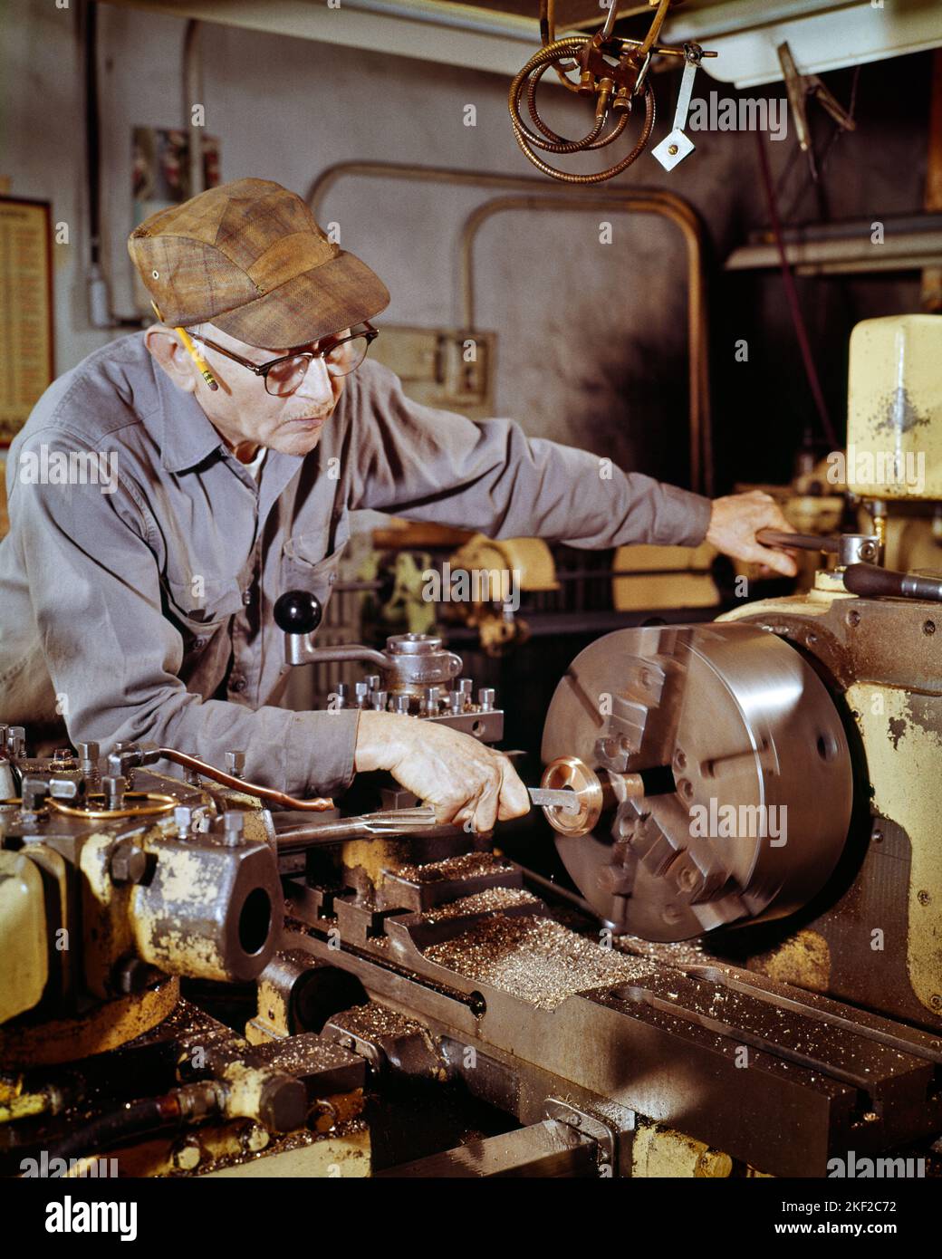 1960s MIDDLE-AGED MAN WORKER MACHINIST OPERATING A TURRET LATHE IN A ...