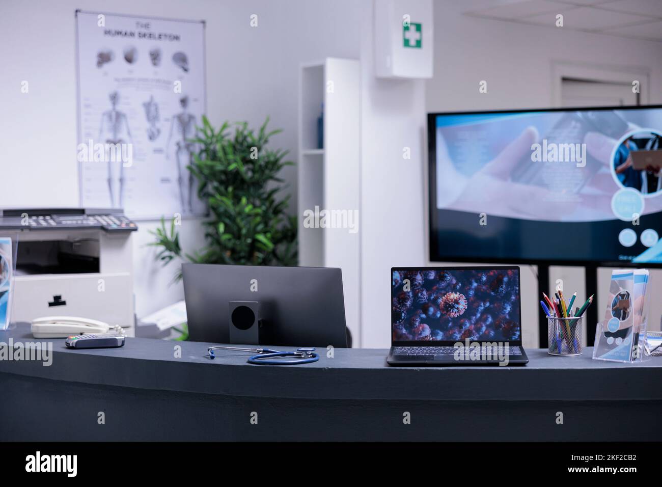 Laptop screen on empty front desk showing sample of coronavirus cell ...