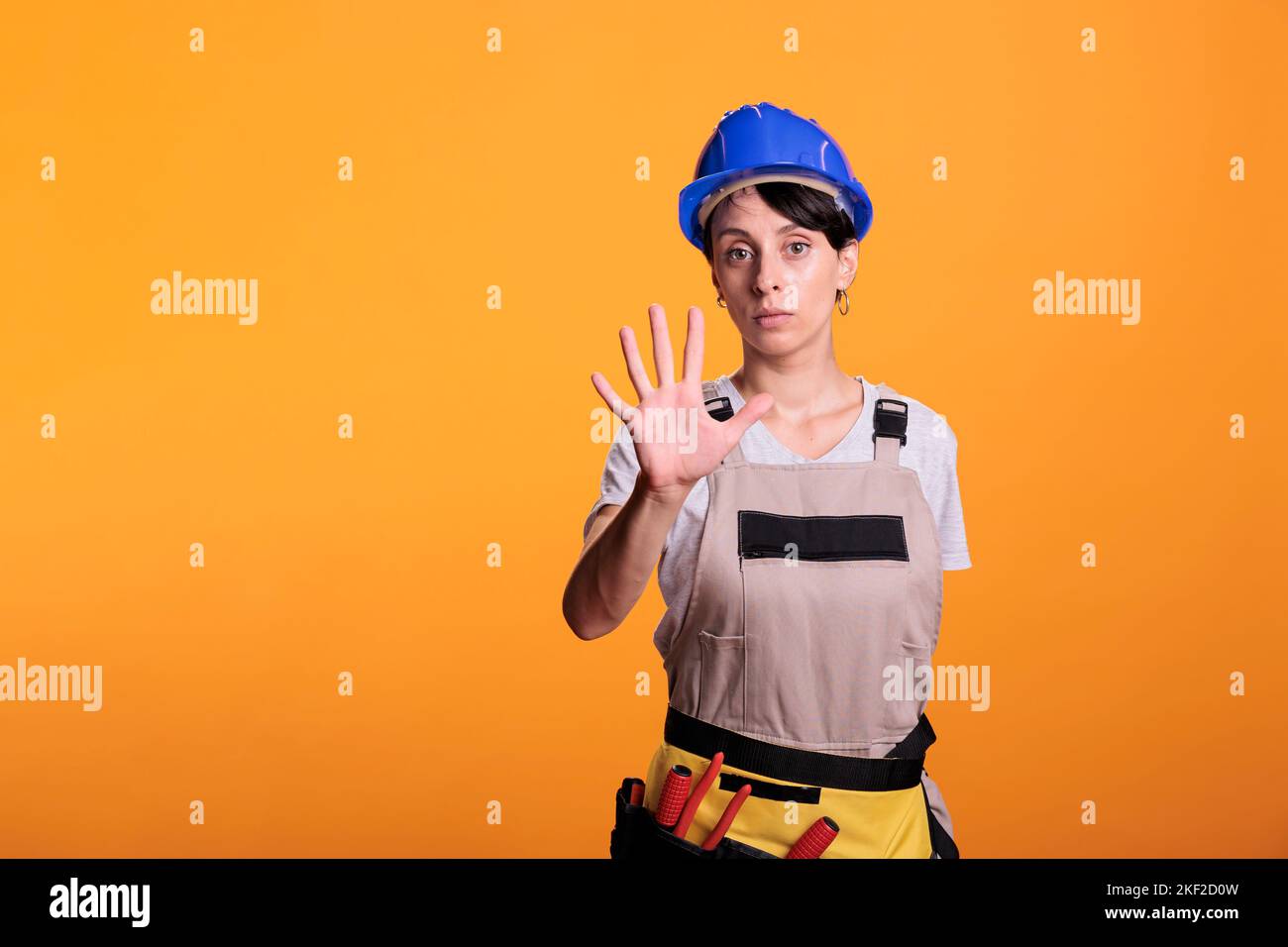 Young handywoman disapproving rejecting idea, raising palm to show ...