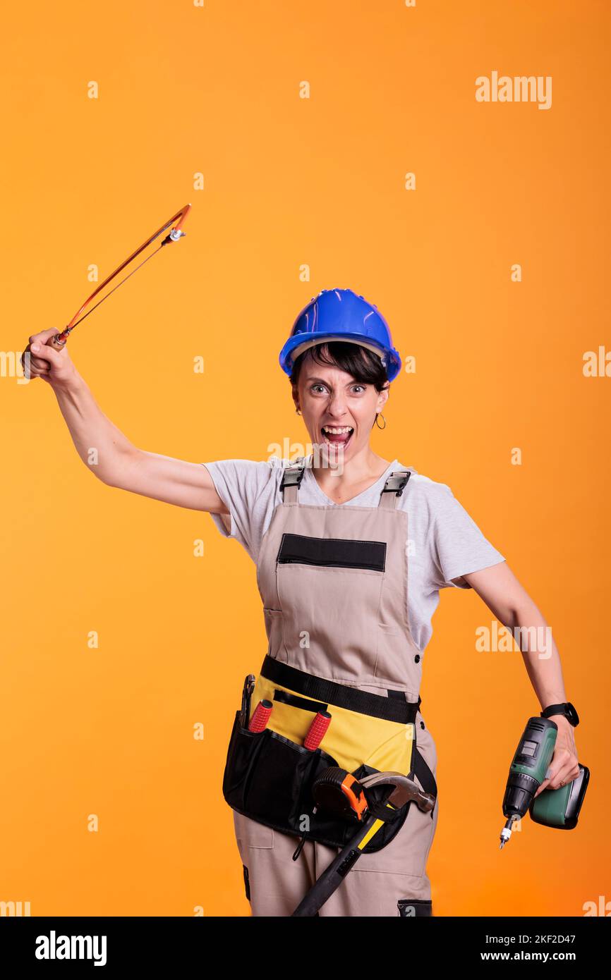 Angry construction worker with chainsaw and power drill acting crazy in ...