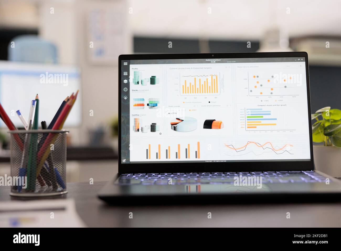 Portable computer with statistical infographics on a desk in an empty ...