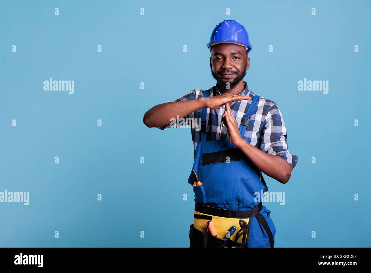 Construction worker making the pause gesture on camera, showing the T ...