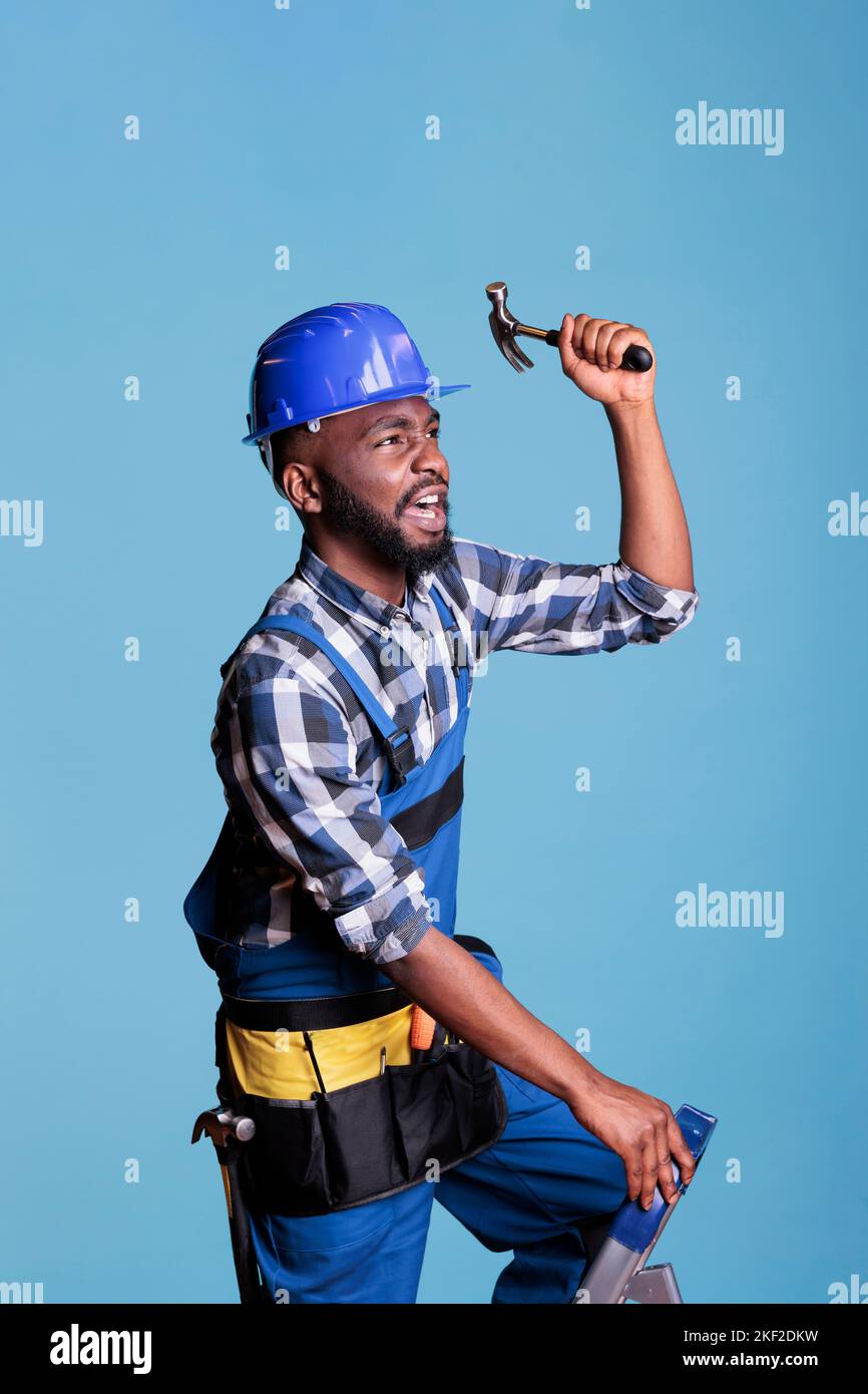 African american construction worker using hammer with determination ...