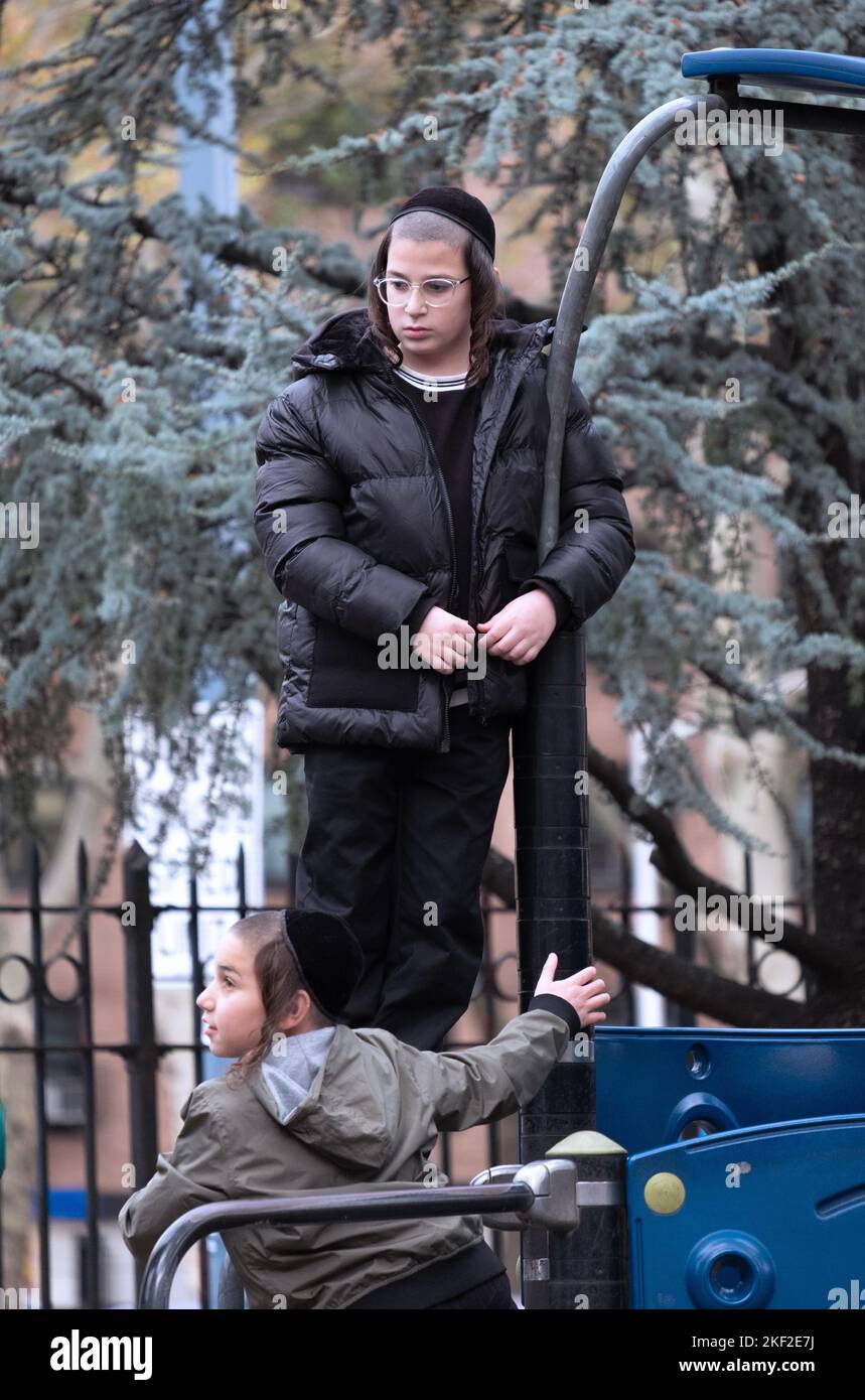 During recess at his yeshiva, 2 orthodox Jewish boys with peyot stand ...