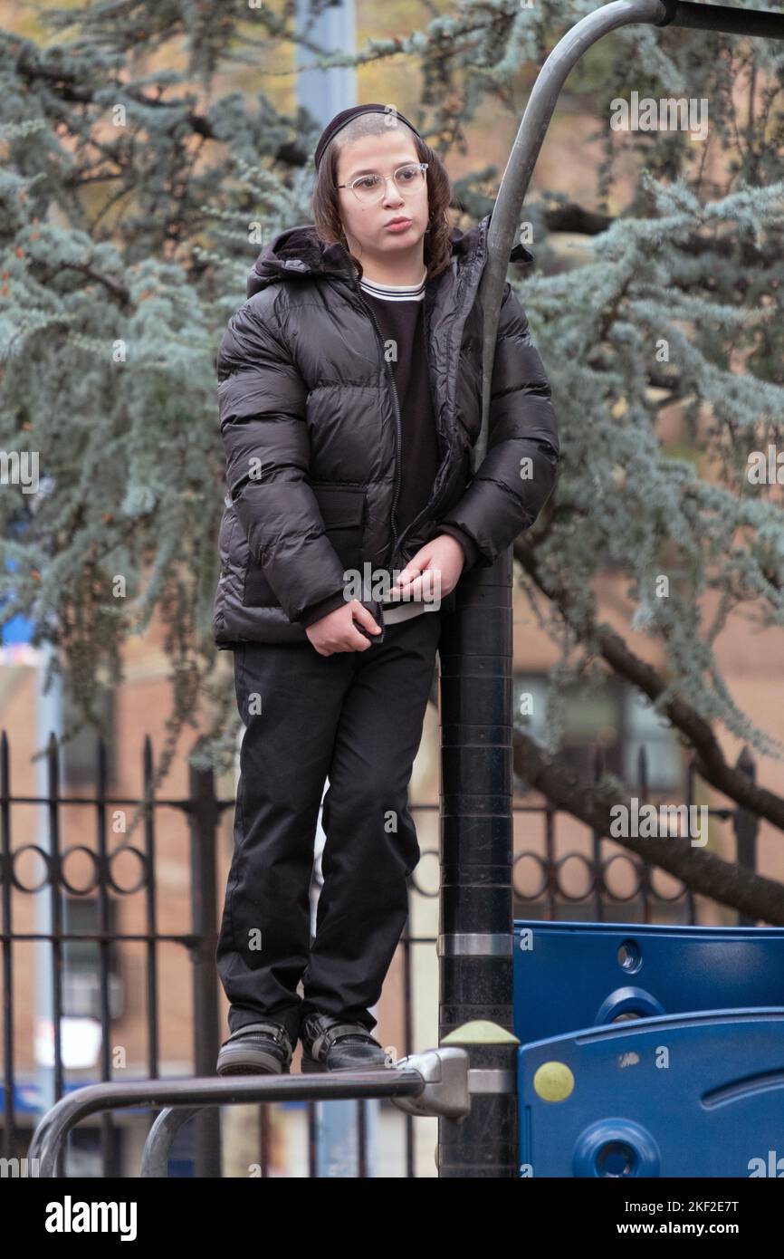 During recess at his yeshiva, an orthodox Jewish boy with peyot stands ...