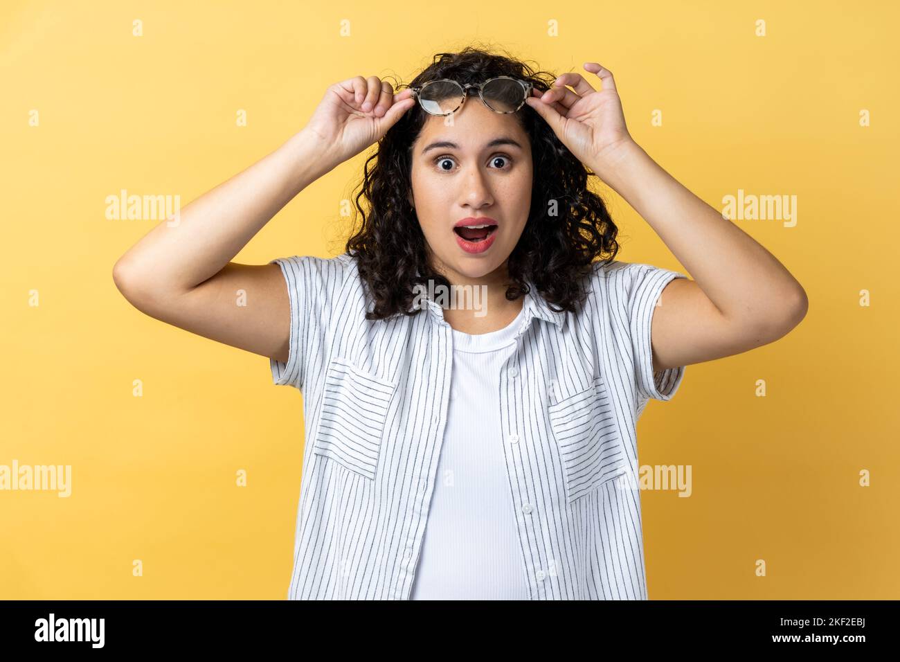 Portrait of surprised astonished woman with dark wavy hair standing ...