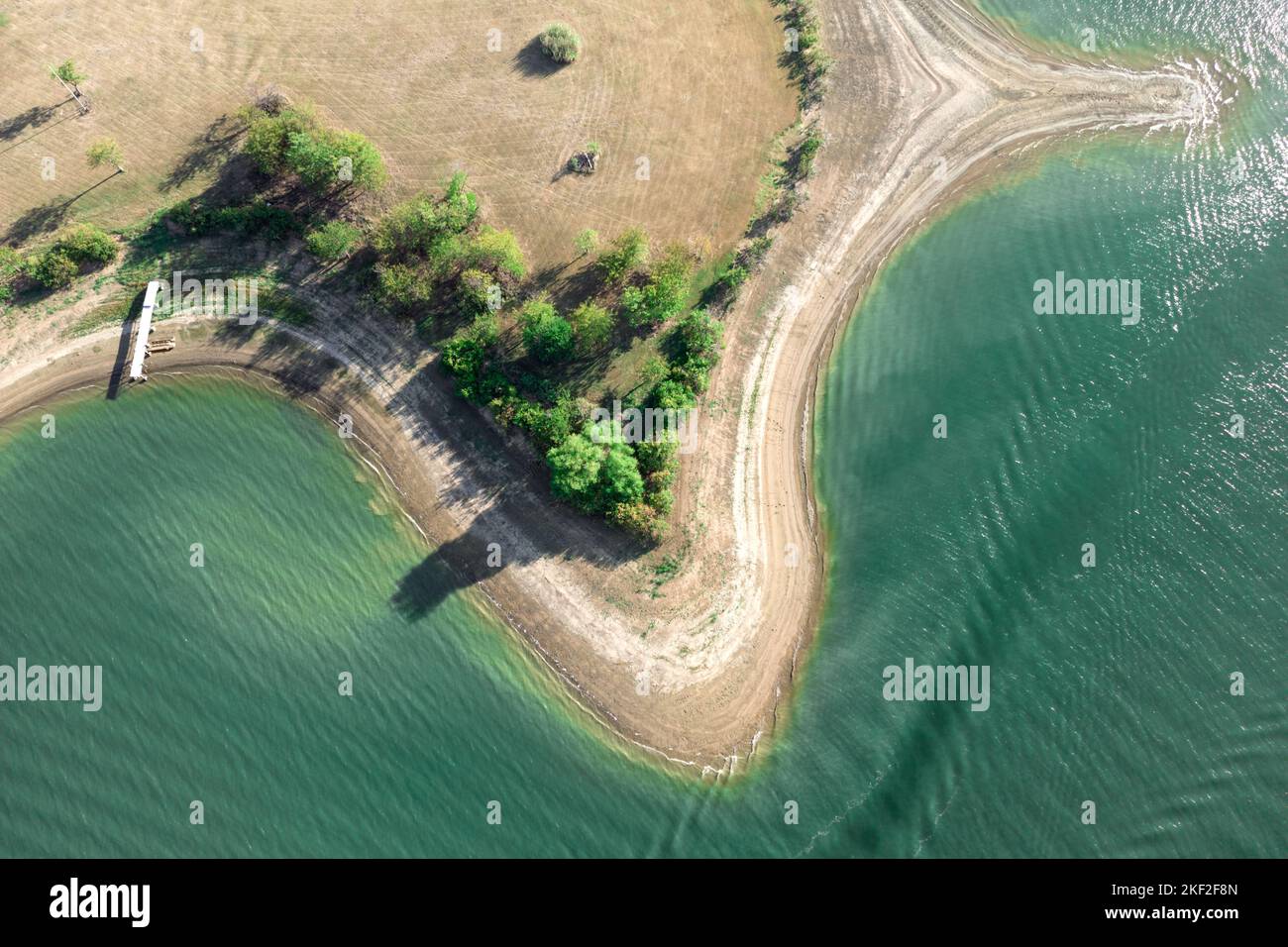 Aerial view of island with green trees and roads surrounded by sea or ...
