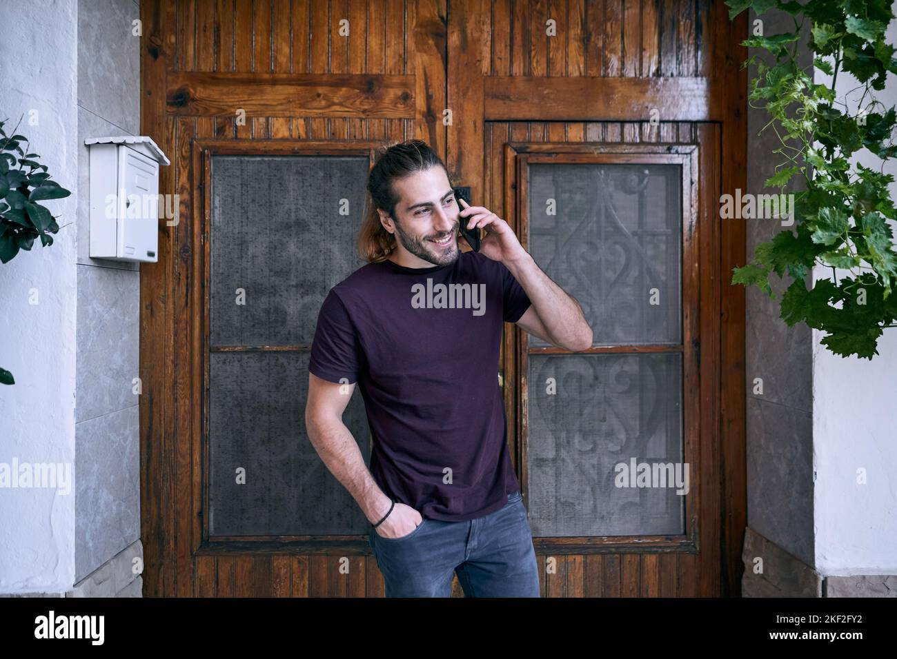 caucasian young man talking on the smartphone of him smiling next to ...