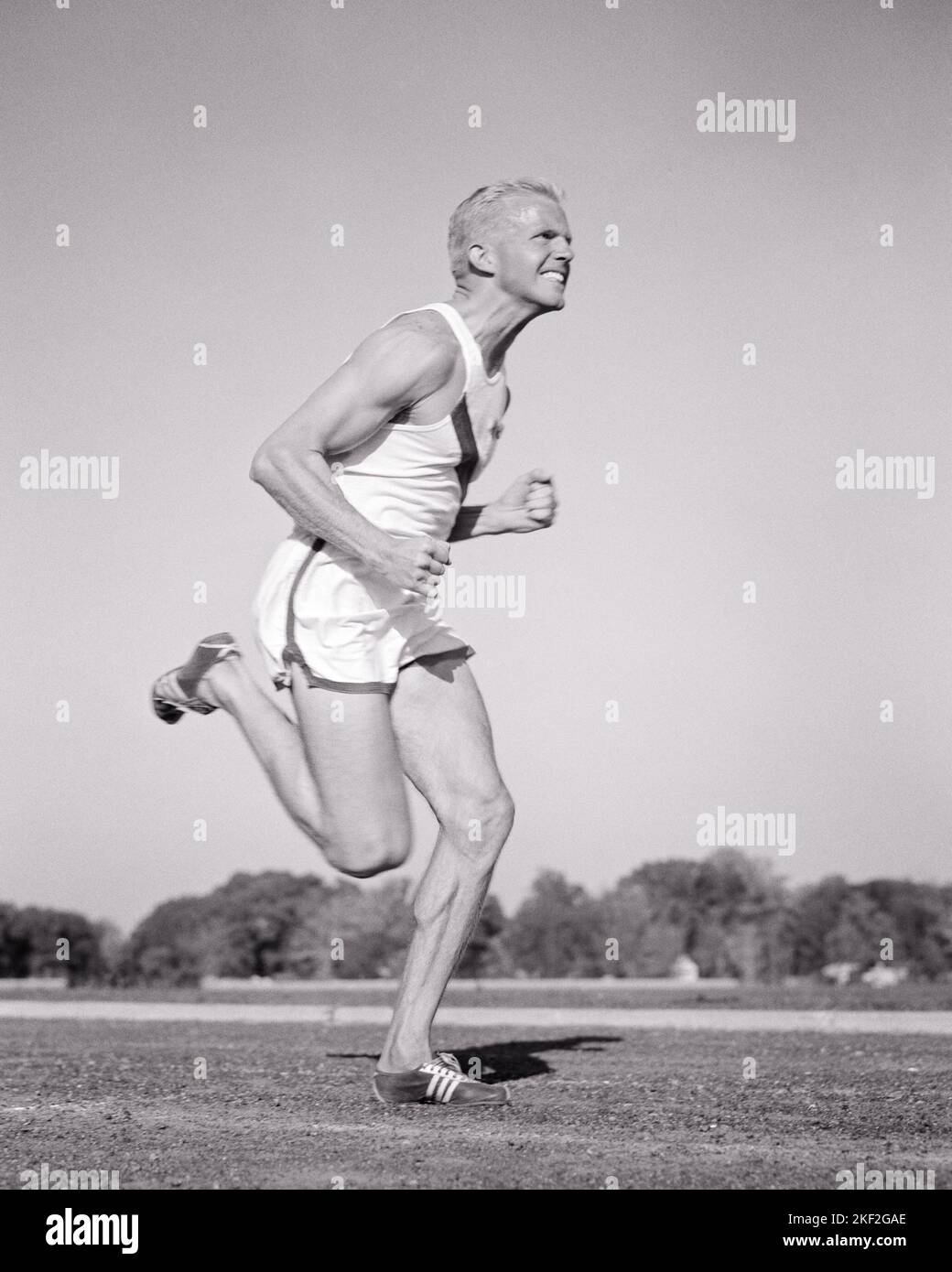 1960s MAN ATHLETE IN UNIFORM RUNNING IN TRACK COMPETITION EVENT ...