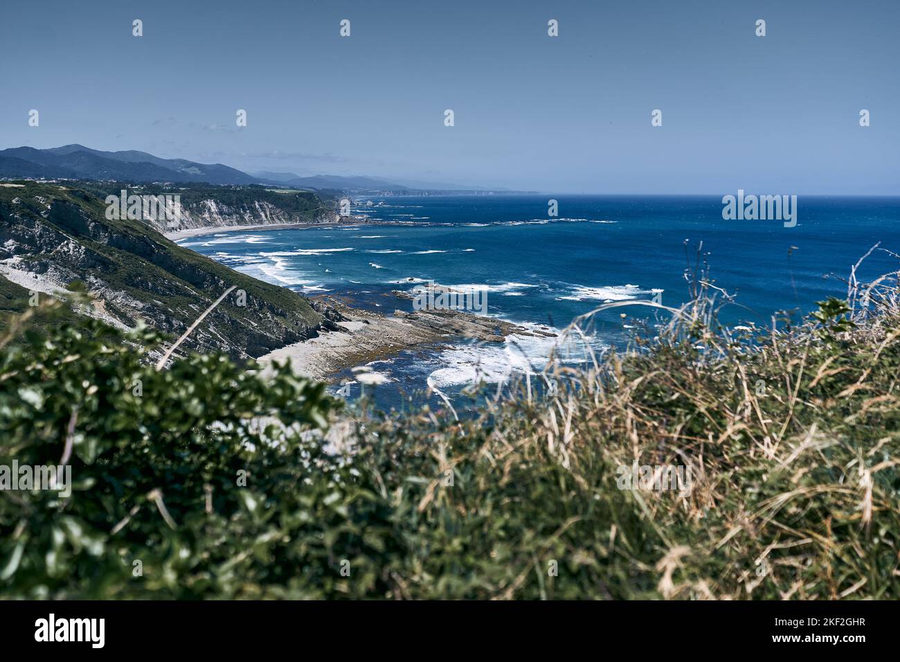 impressive cliffs with big rocks and vegetation in the cantabrian sea ...