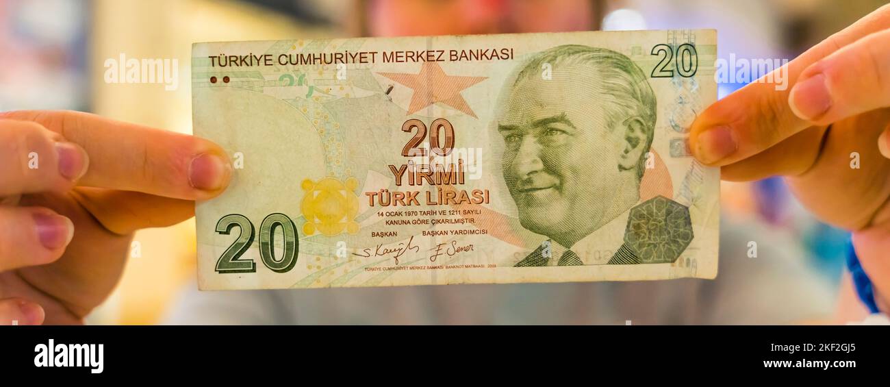 Close-up view of hands holding 20 Turkish Lira bill showing it to ...