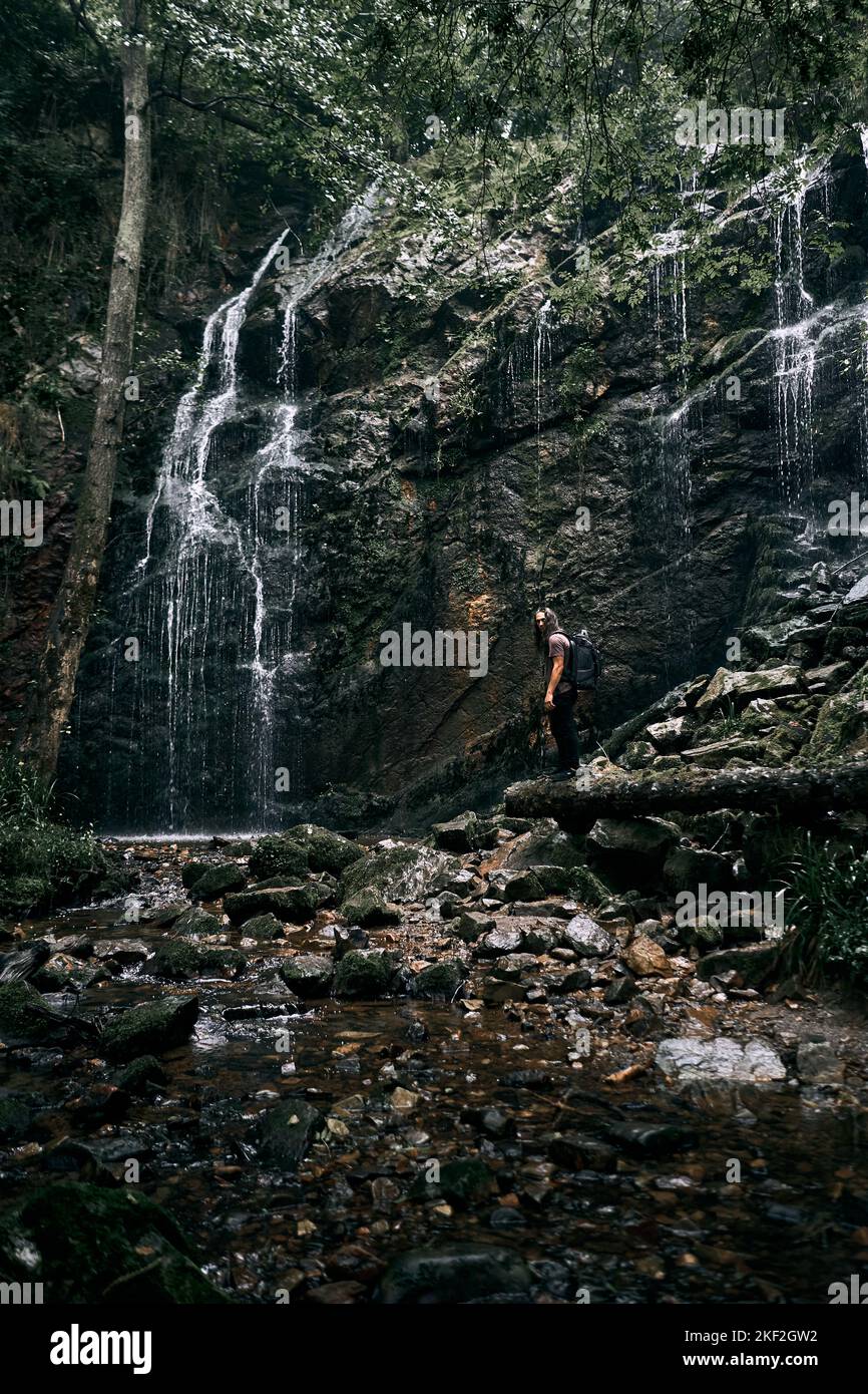 long-haired caucasian boy with backpack on his back standing on a big ...
