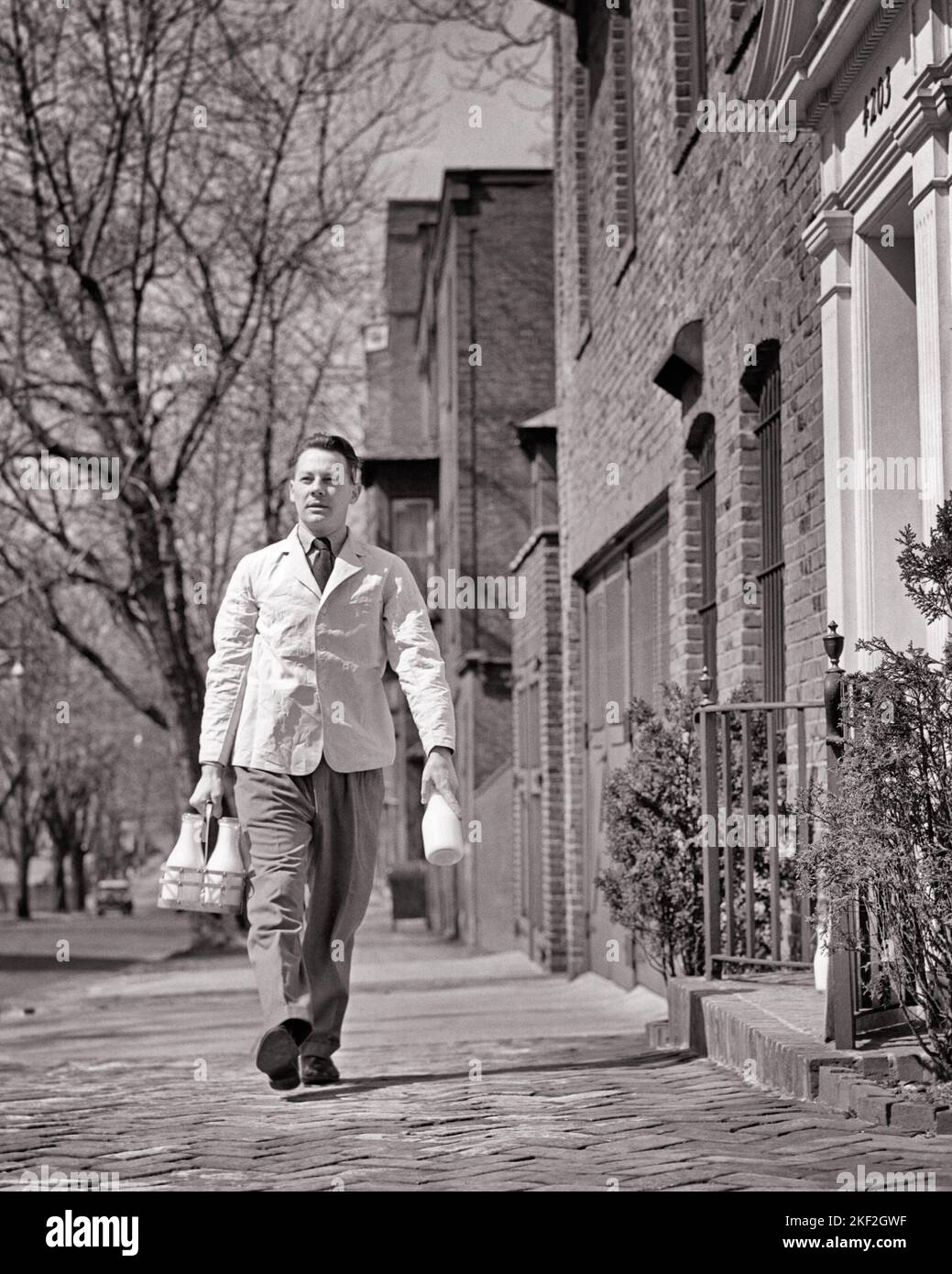 1940s MILKMAN WALKING UP BRICK PAVED STREET WEARING WHITE JACKET ...