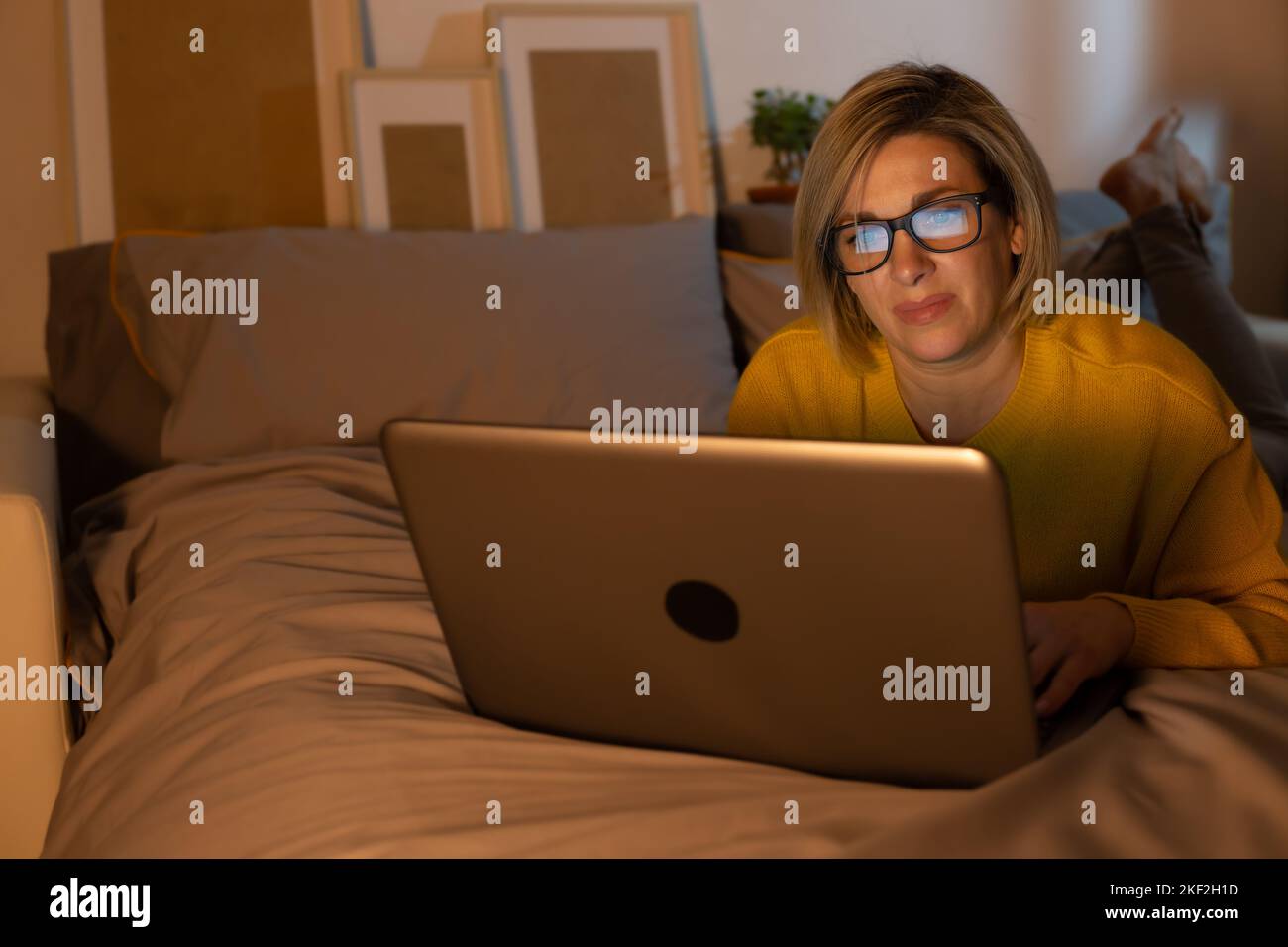 Beautiful caucasian woman 40 years old in glasses uses and works on a ...