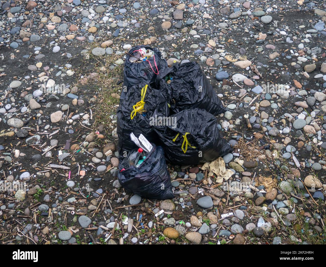 Black garbage bags on gray stones. Depressive mood. Environmental ...