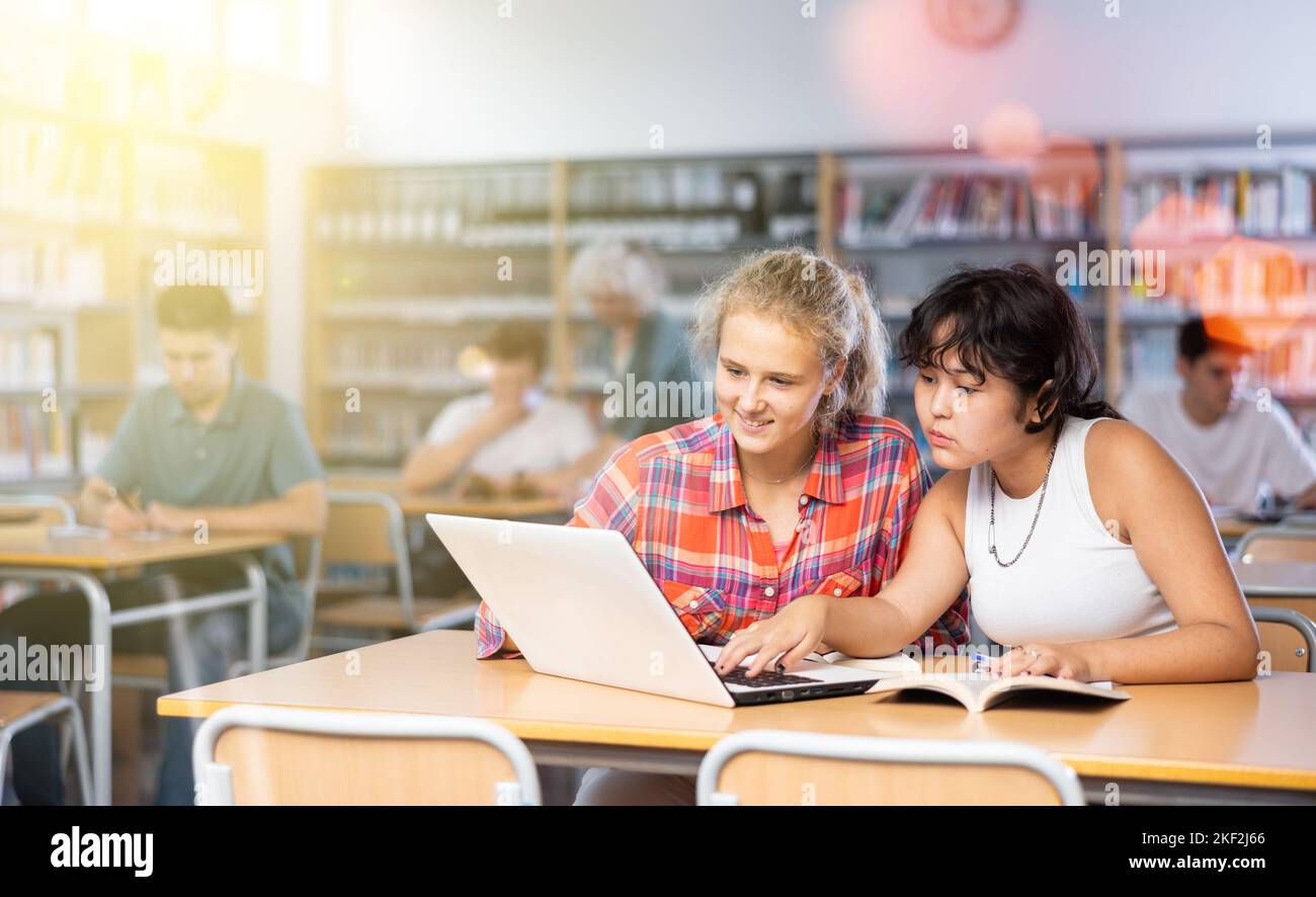 Portrait of asian schoolgirl with spanish female friend studying in ...