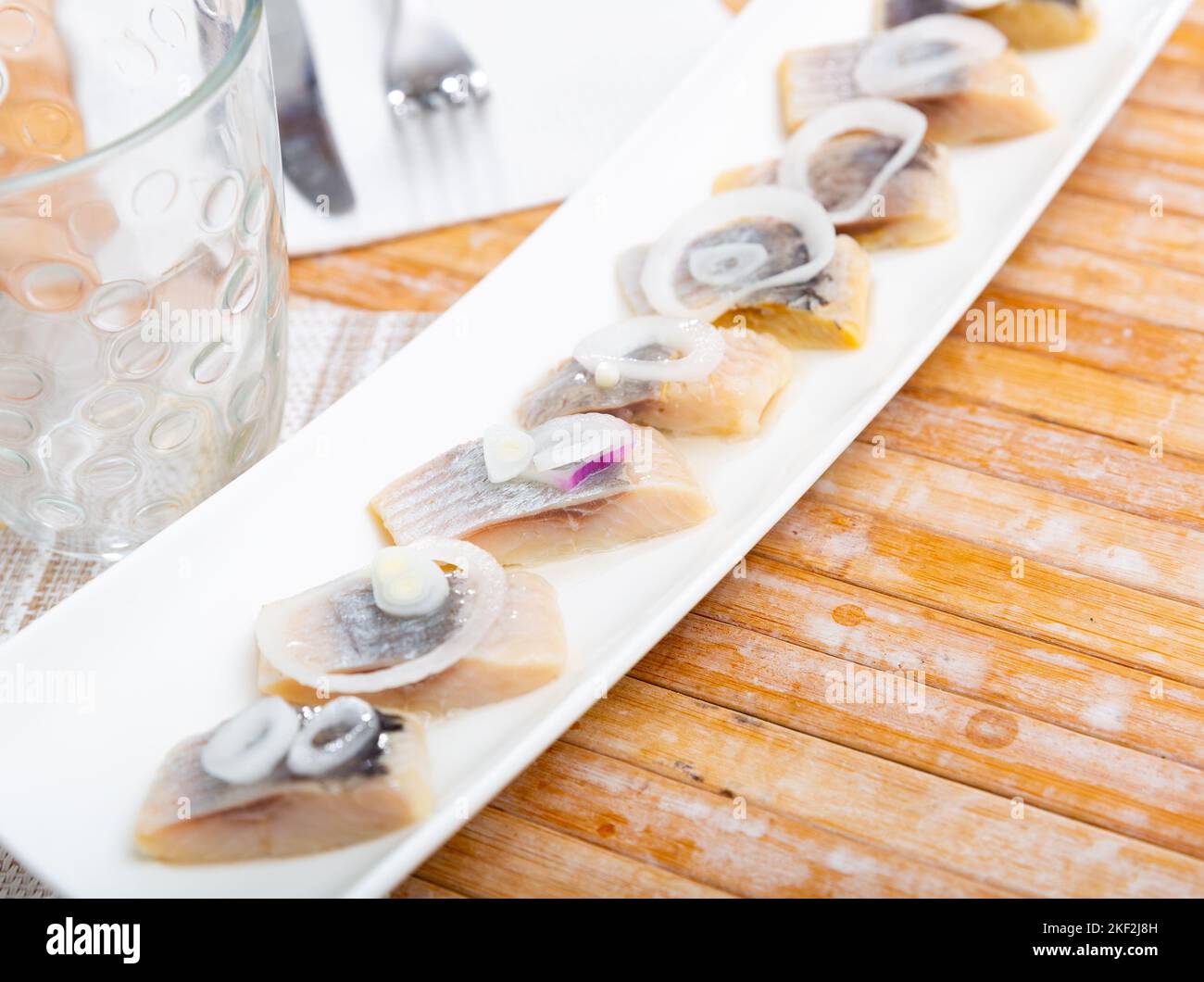 Salted pickled herring fish served on a ceramic plate Stock Photo - Alamy