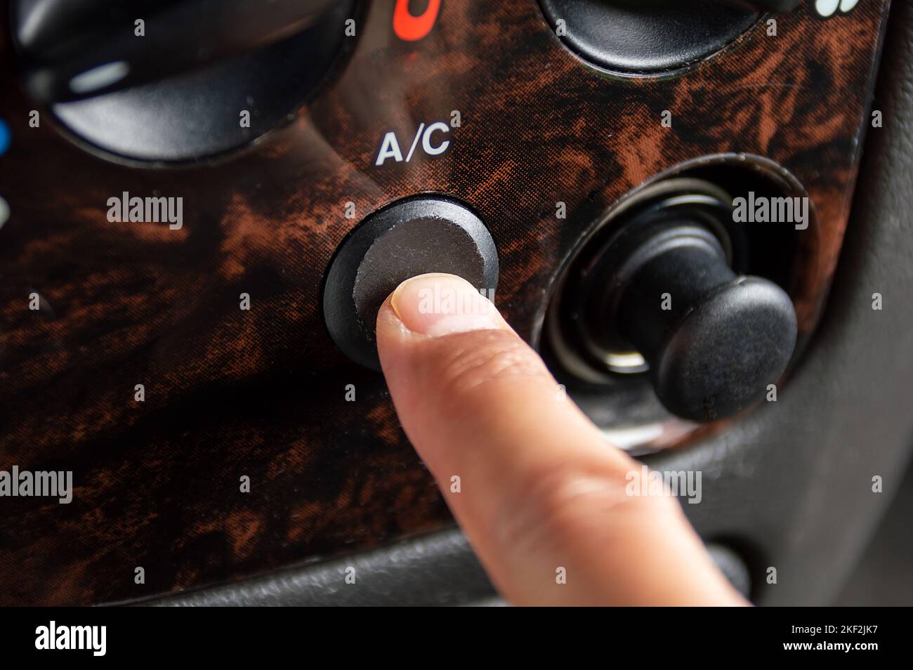 Close-up of an air conditioning button pressed by a man inside a car ...