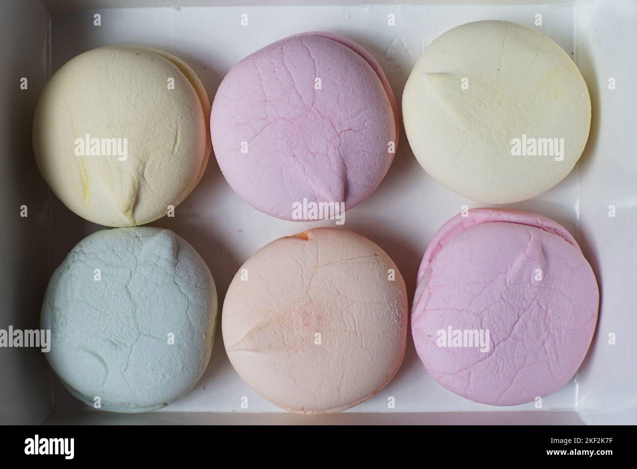 Six colorful handmade marshmallows in a cardboard box on the table ...