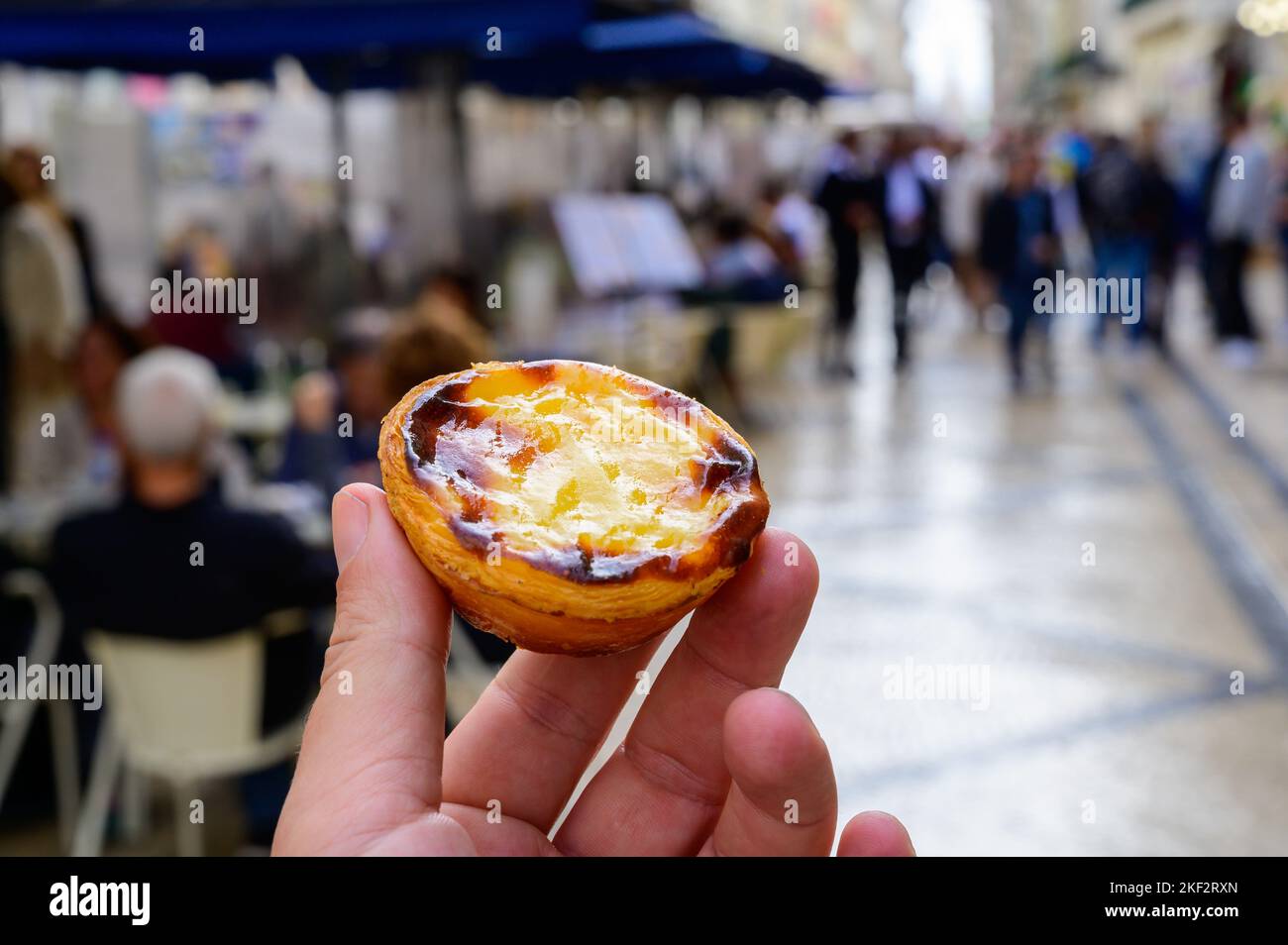 Hand with Portugal's traditional sweet dessert Pastel de nata egg ...