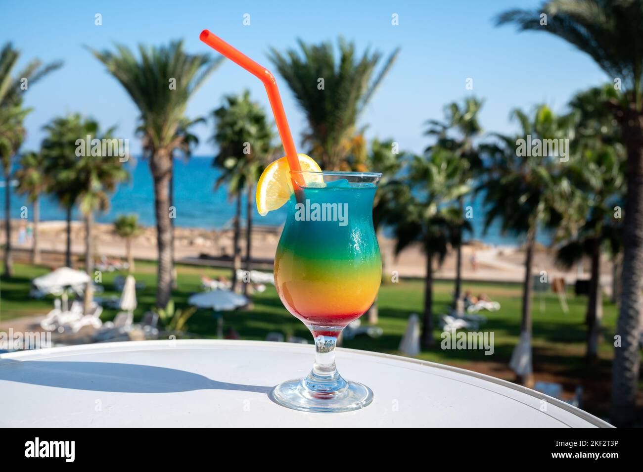 Colourful frozen Rainbow Paradise cocktail drink served in glass at ...