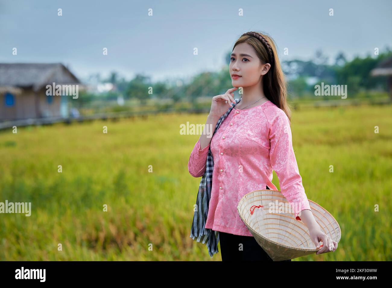 Sa Dec city, Vietnam: portrait of a girl in the Southwest region of Vietnam in a ripe rice field ...
